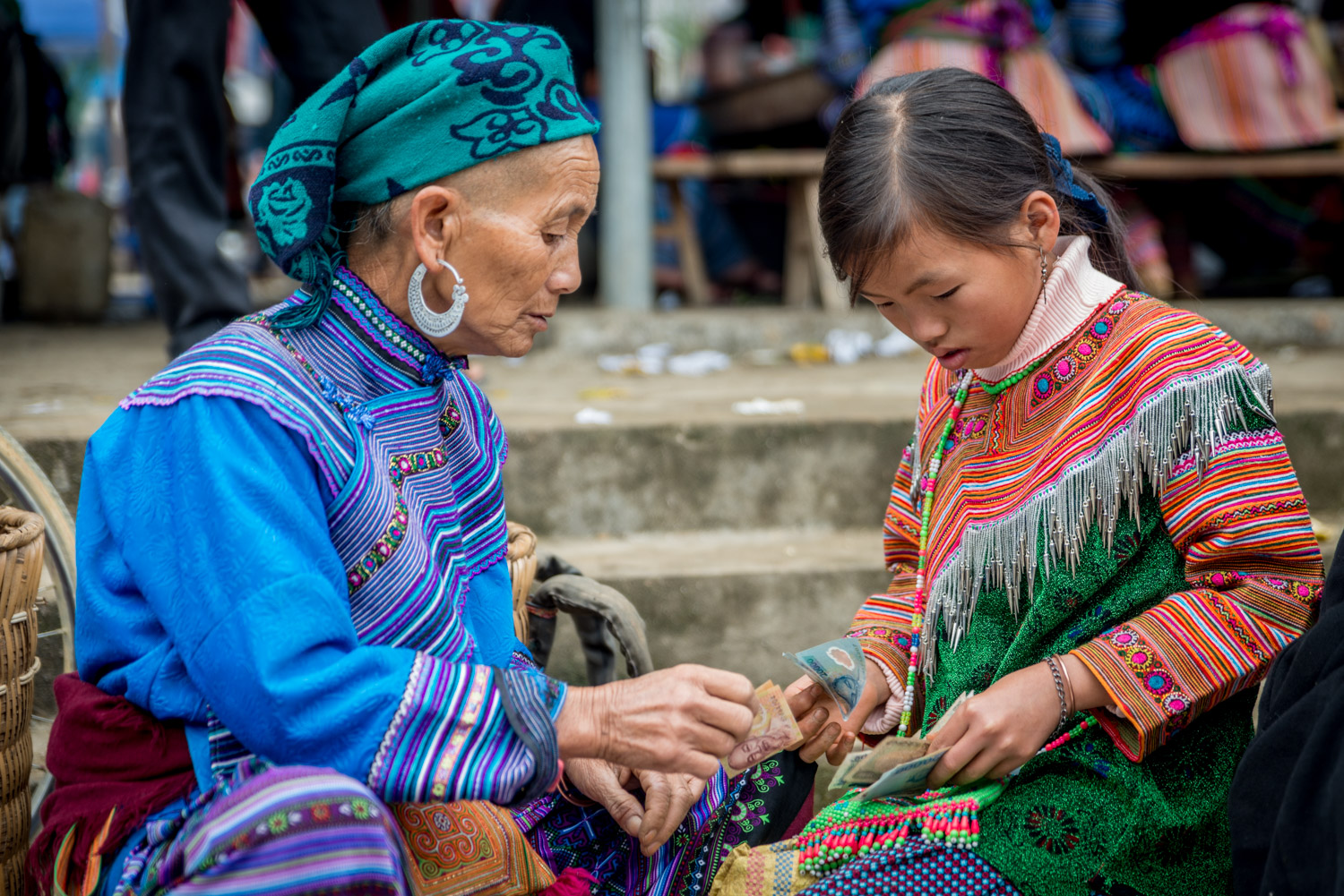 A Blue Hmong woman makes a transaction with a young Flower Hmong ...